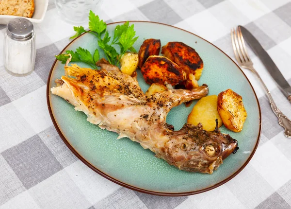 Appetizing homemade baked rabbit pieces and potato slices served with ...