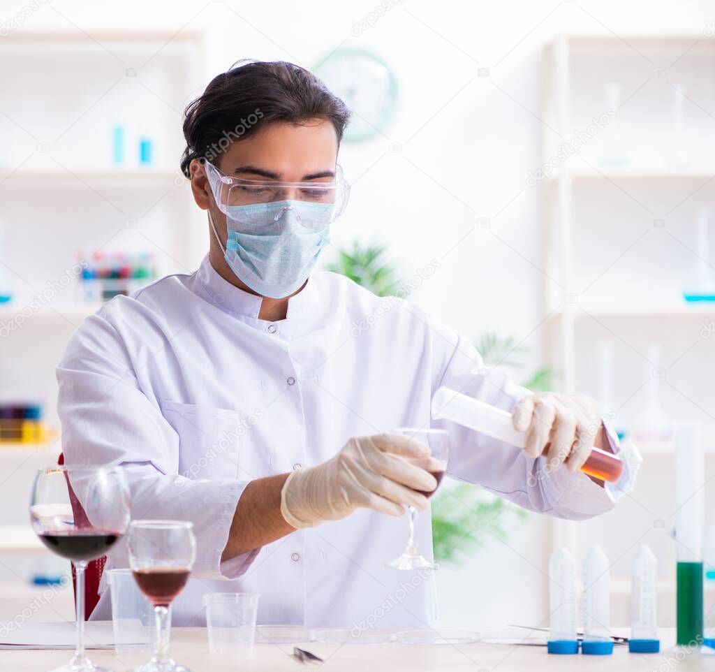 El qu mico masculino examinando muestras de vino en el laboratorio 2024