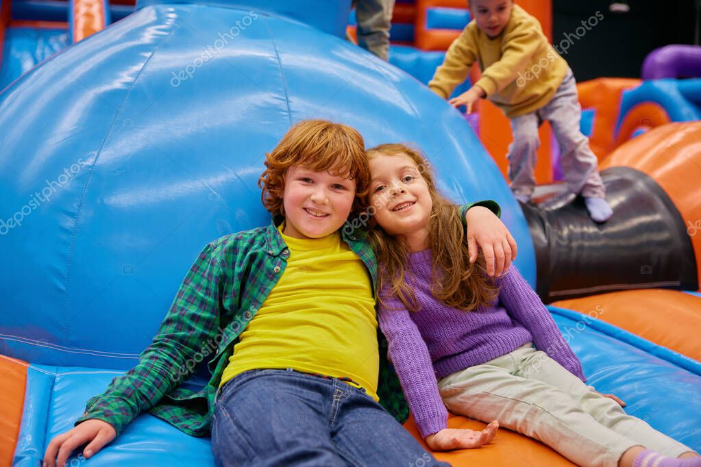 Lindos niños pequeños de diferentes edades jugando en la casa inflable ...
