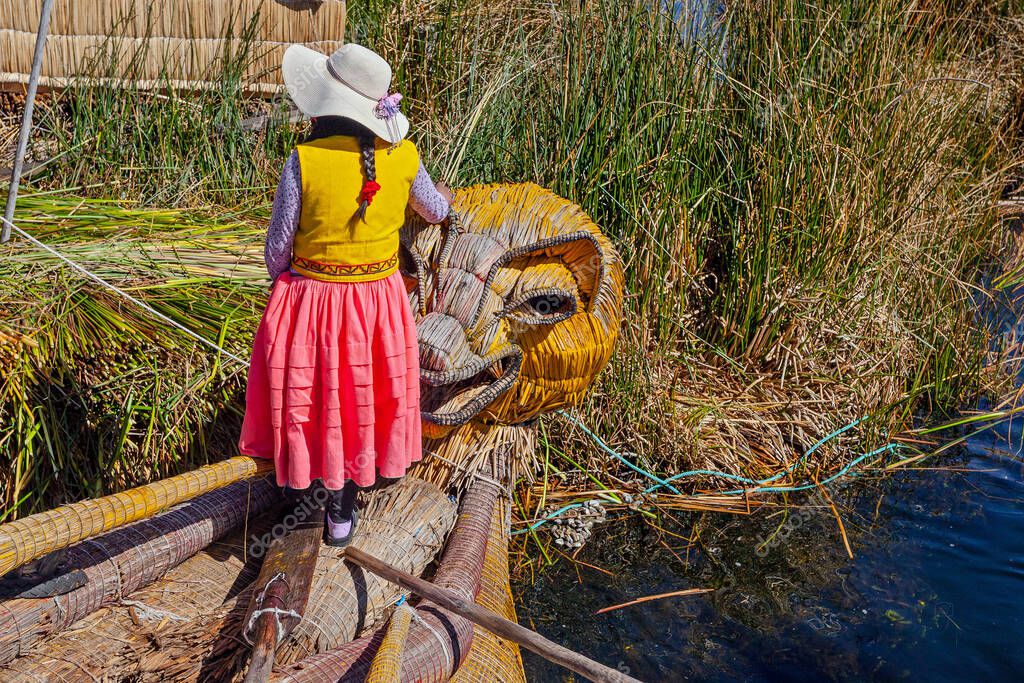 Uros, Peru - April 29, 2022: woman in traditional clothes rowing a uros ...