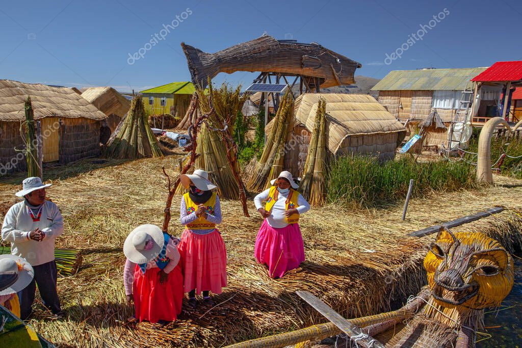 Uros, Peru - April 29, 2022: women in traditional dresses near house on ...