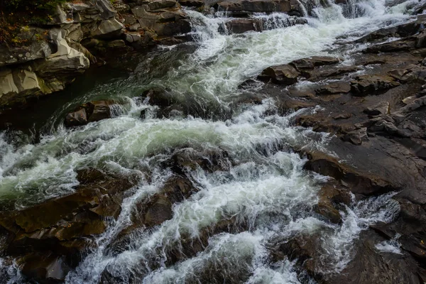 rapids of mountain rivers with fast water and large rocky boulders ...