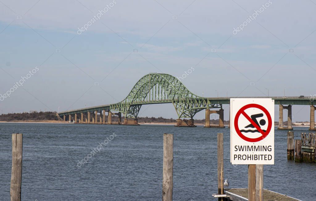 Swimming prohibited sign with the Robert Moses Bridge in the background ...
