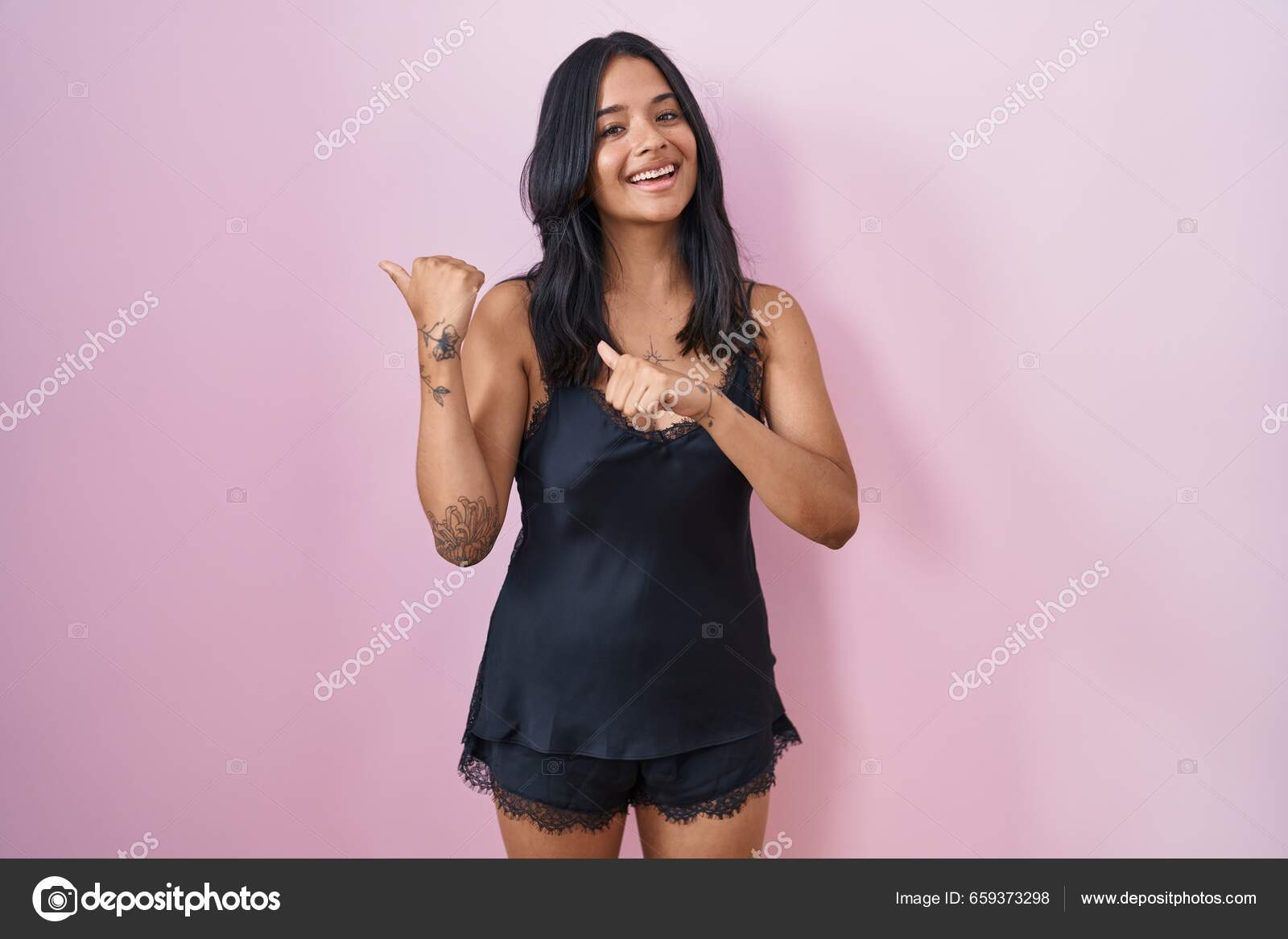 Brunette Woman Wearing Black Pajama Pointing Back Hand Thumbs Smiling