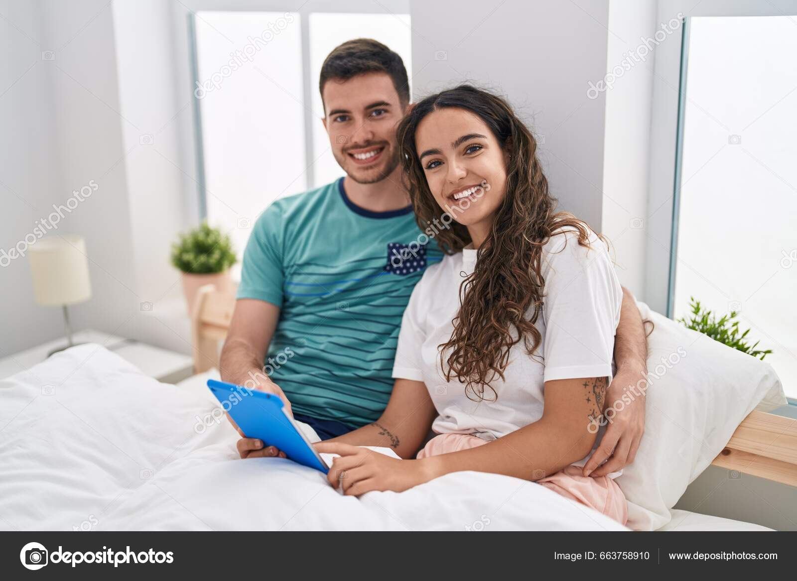 Young Hispanic Couple Using Touchpad Sitting Bed Bedroom — Stock Photo © Krakenimages.com #663758910