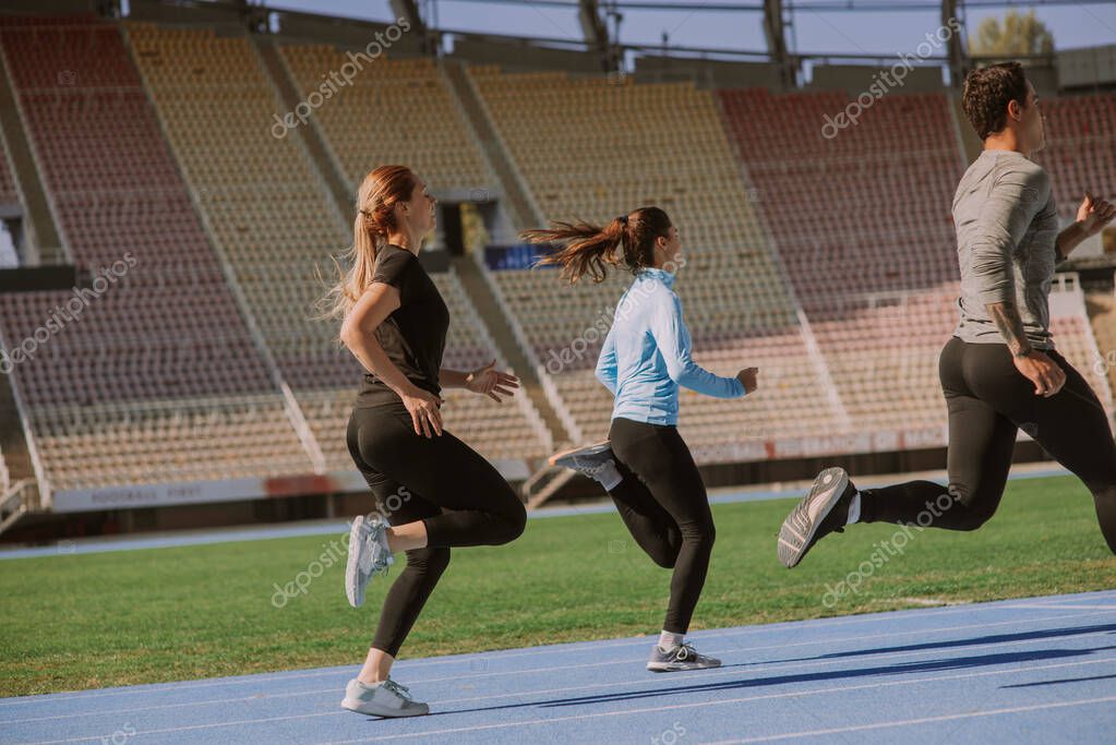 Tres amigos corriendo en una pista deportiva azul 2023