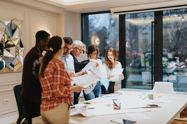 Multicultural business team collaborating in modern office. Focused ...