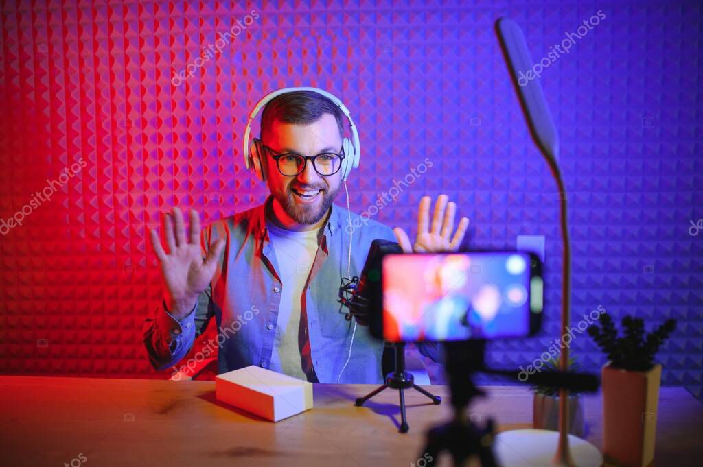 Un joven grabando o transmitiendo podcast usando micr fono en su peque o estudio de transmisi n ...