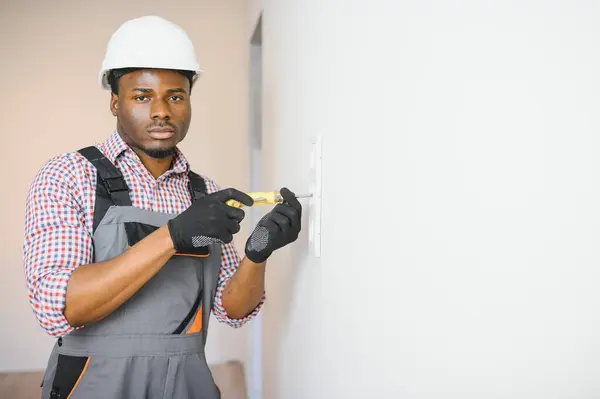 young male electrician install electrical outlets and switch. - Stock ...