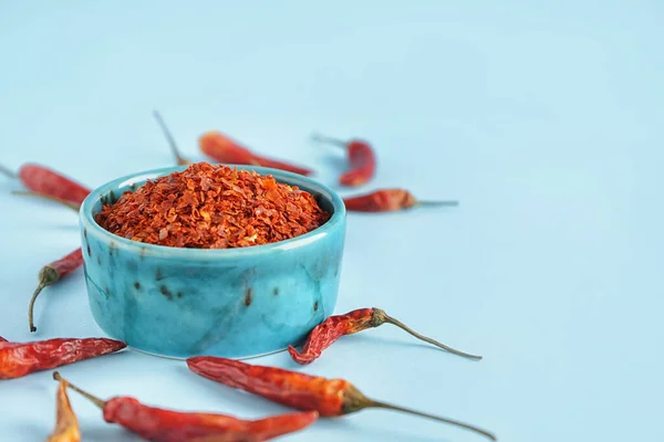 Bowl of chipotle chili flakes and dried jalapeno peppers on color ...