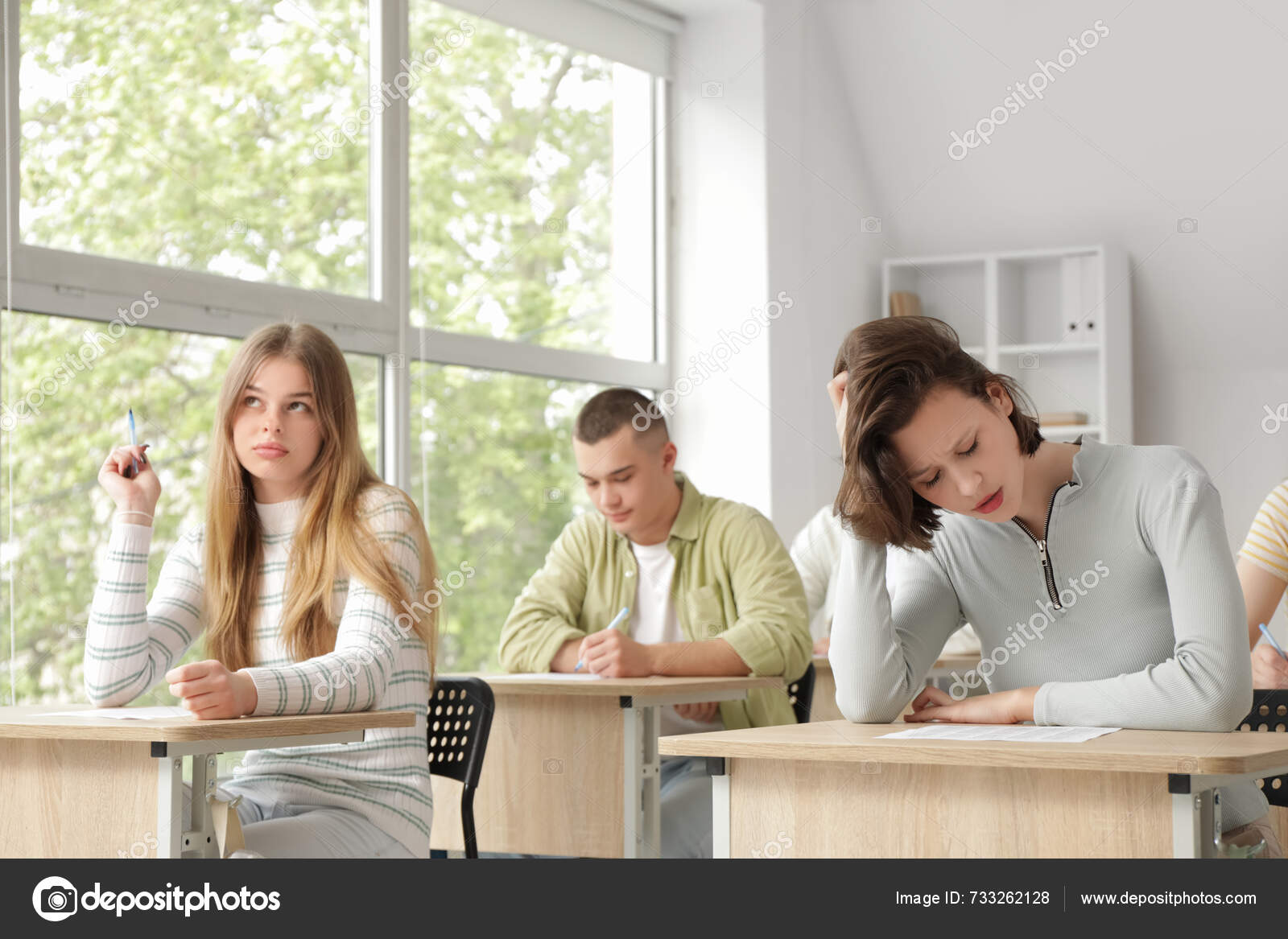 Students Passing Exam Desks Classroom — Stock Photo © serezniy #733262128