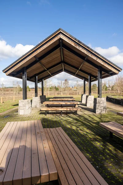 Outdoor recreational space covered area with picnic tables and trees ...