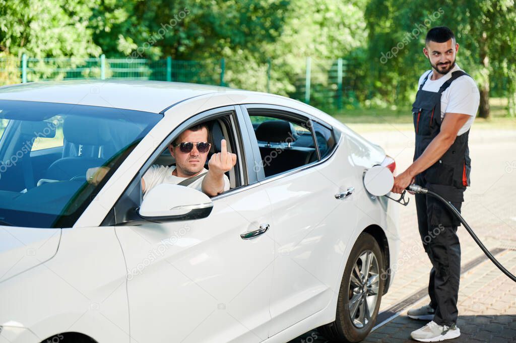 Conductor grosero mostrando el dedo medio a otro coche en la gasolinera ...