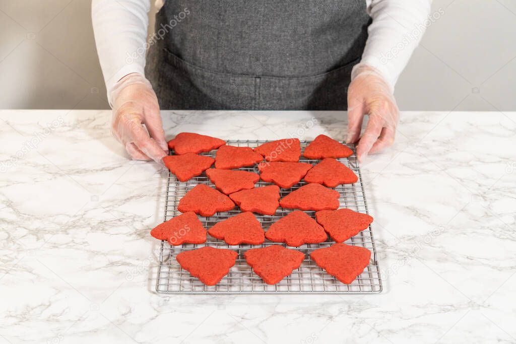 Un estante de enfriamiento lleno de galletas de jengibre rojas en forma ...