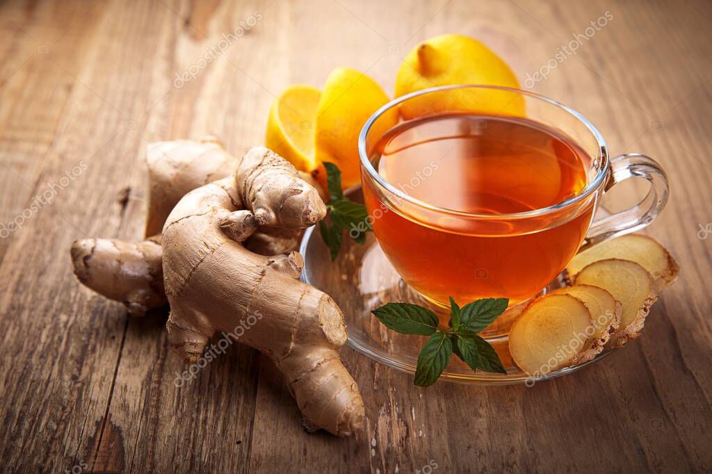 Té de jengibre con miel de limón y tomillo en tabla de madera blanca en ...