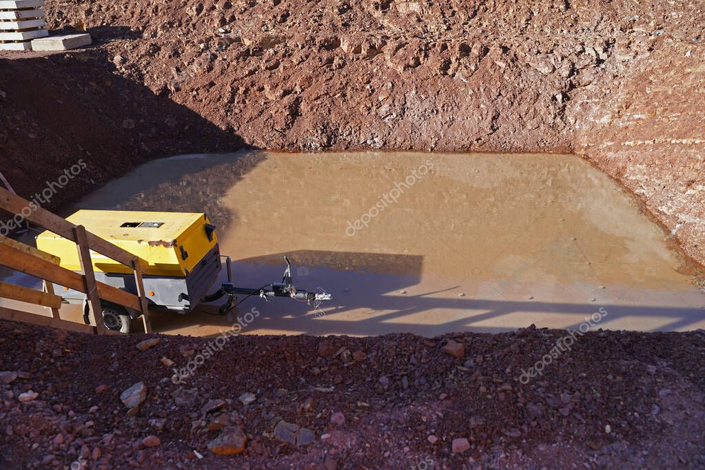 Pumping out water in the excavation pit before pouring the bottom ...