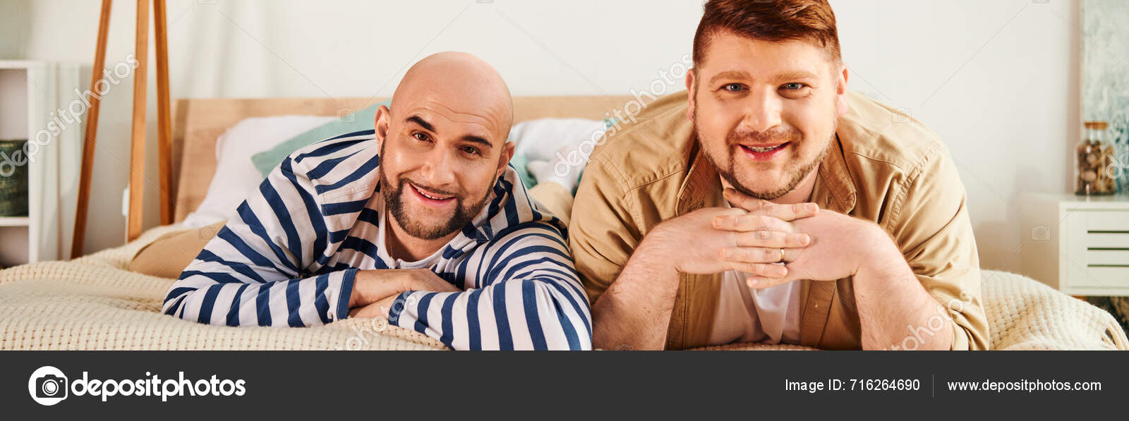 Two Men Cuddling Bed Looking Camera — Stock Photo © IgorVetushko #716264690