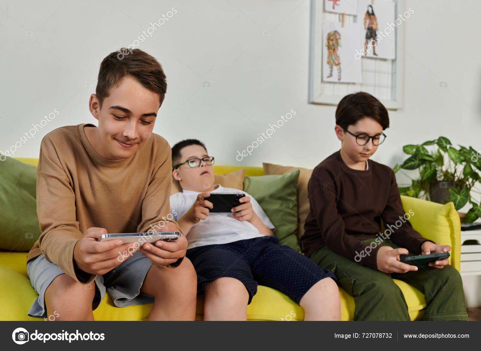 Three Boys Including One Syndrome Sit Yellow Couch Playing Mobile ...