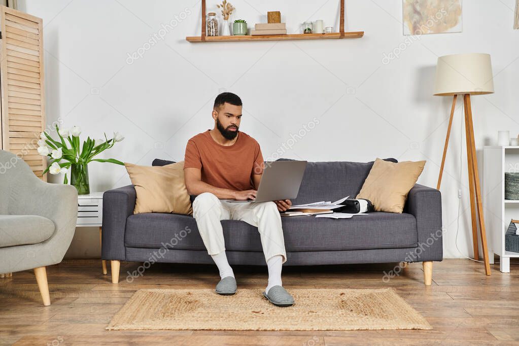 Un hombre está sentado cómodamente en un sofá, trabajando en su ...
