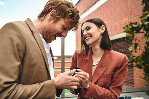 A man and a woman stand side by side, their gazes meeting, emanating a ...