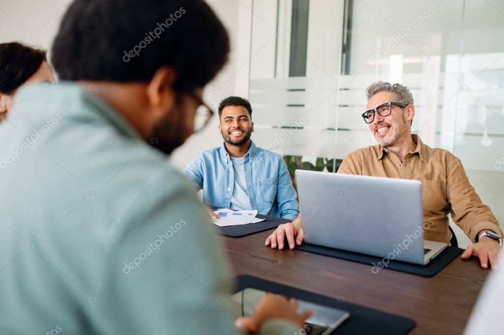 En una oficina moderna, un equipo muy unido se ve en una discusión ...
