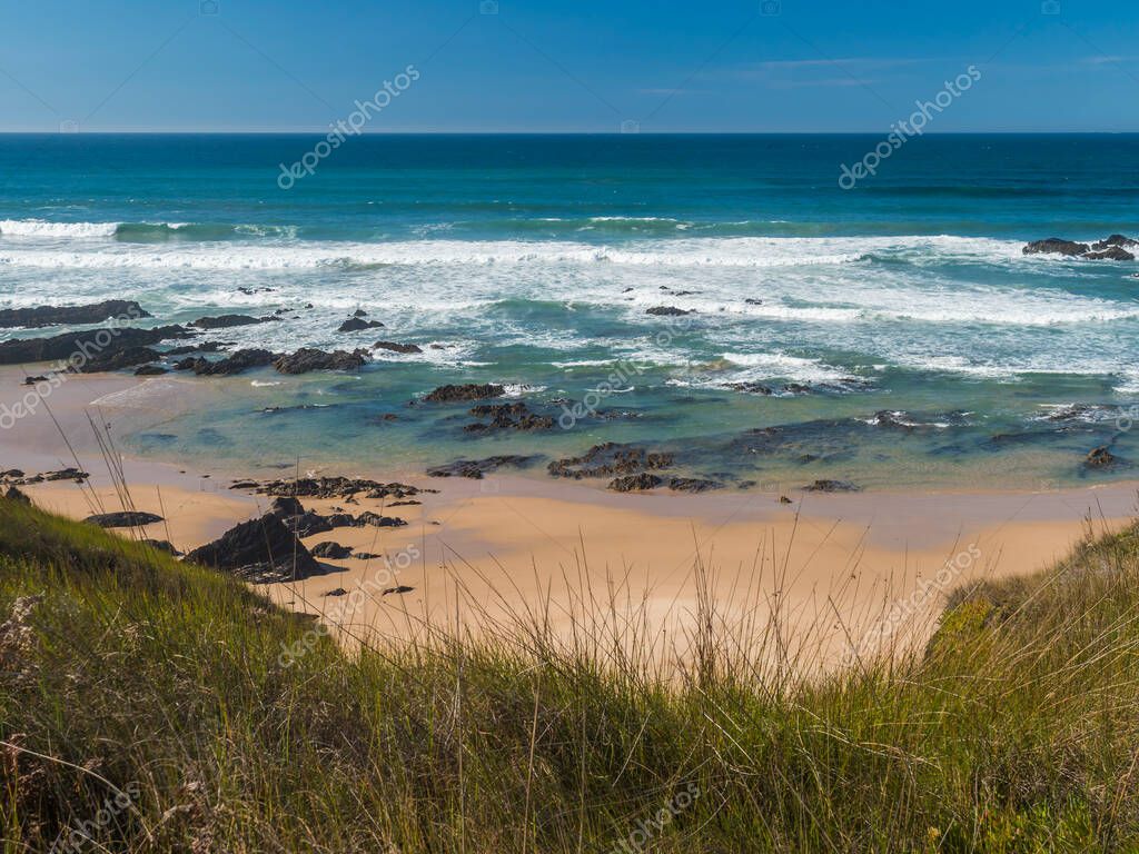 Vista de la playa vacía de Praia dos Picos con olas del océano, piedra ...