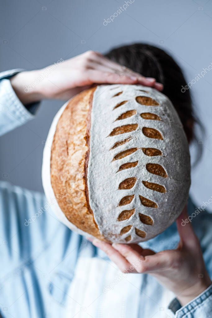 Sourdough Bread Scoring pattern. A woman covering her face with freshly ...