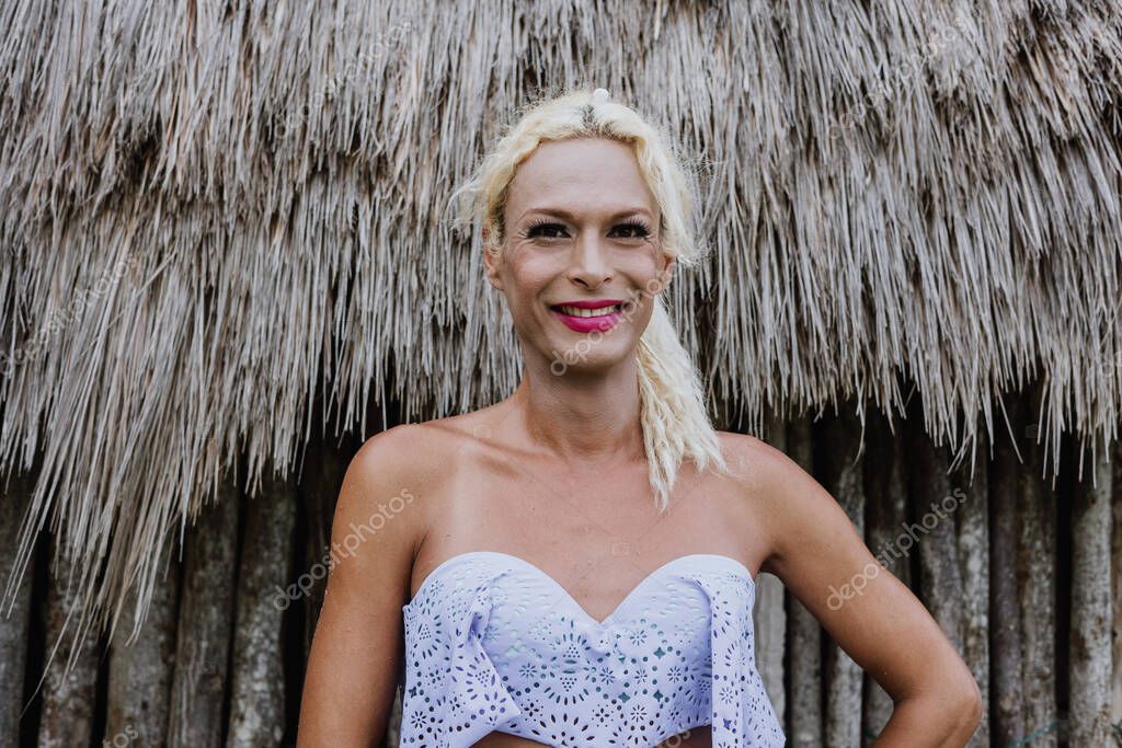 Joven hombre transgénero con maquillaje y ropa de mujer en la playa de ...