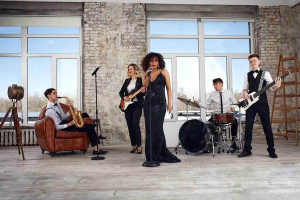 Repetition of multi ethnic jazz band in loft. Bass guitar player ...