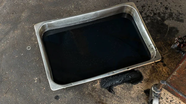 Old oil tray that was removed from the automobile. Old black oil ...