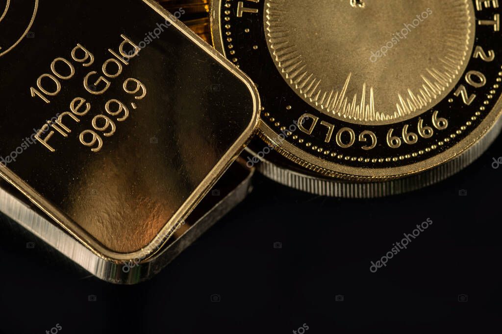 100 gram gold bar and a 2 troy ounce gold coin on a black background. 2023