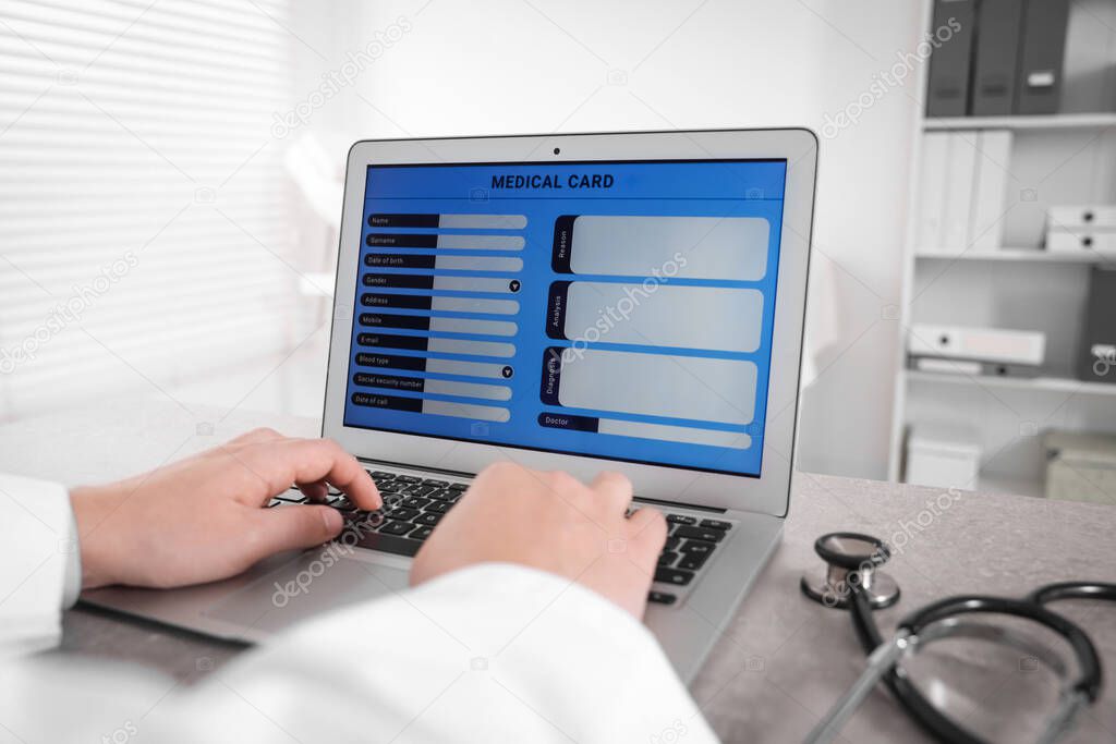 M dico usando el ordenador port til para llenar la tarjeta m dica del paciente en la mesa en la ...