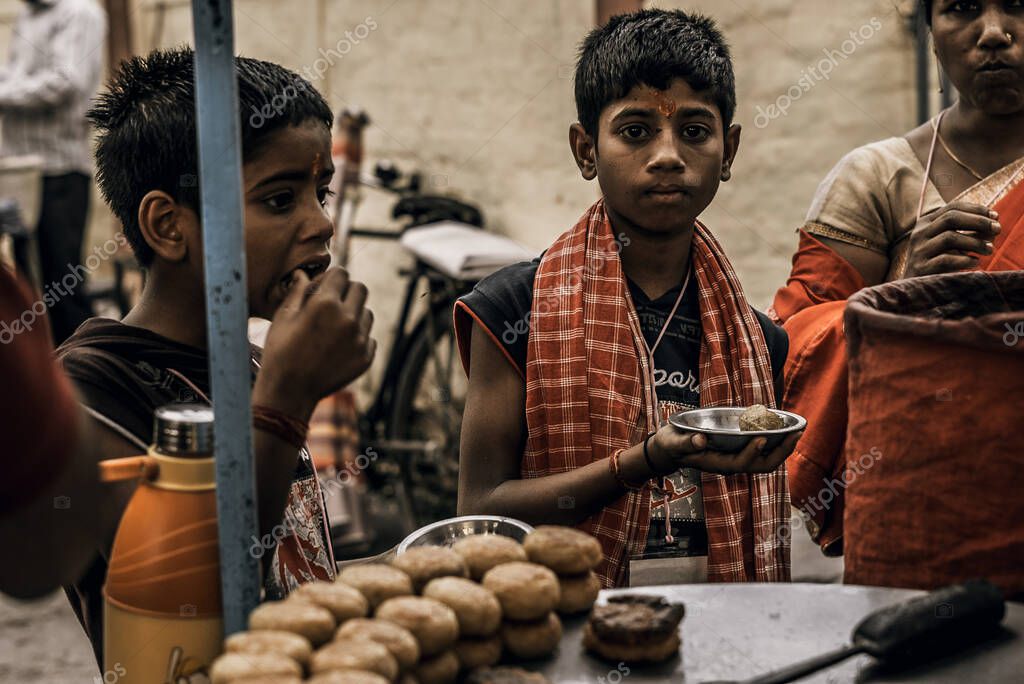 Rishikesh, 2017, niño indio con su madre y su hermano comen comida ...