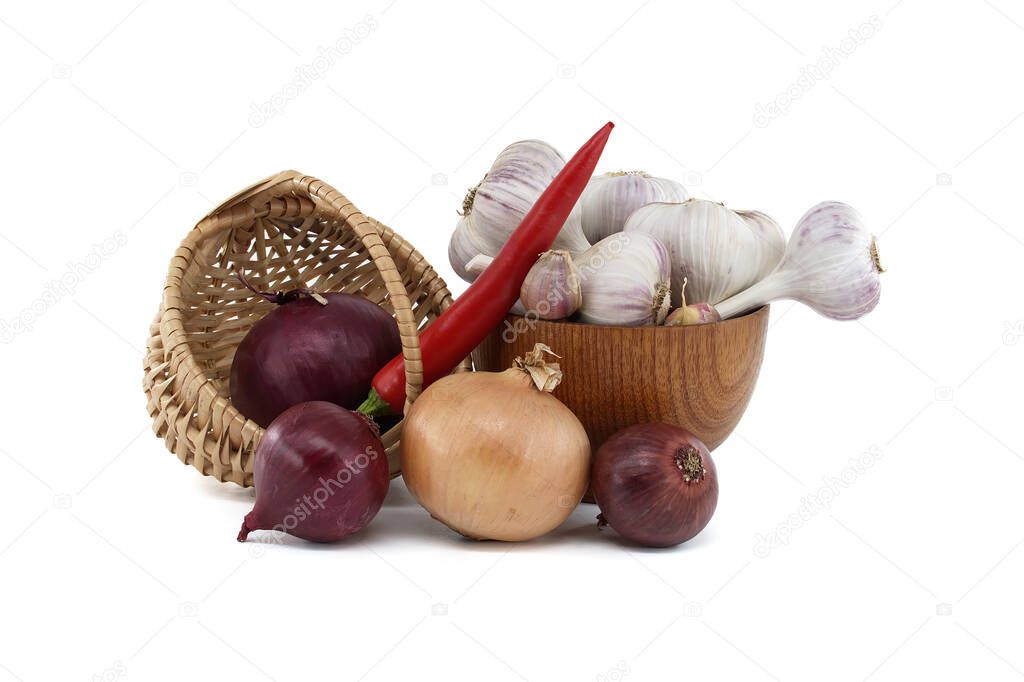 Cebollas rojas y amarillas en canasta de mimbre, bulbos de ajo y clavos ...