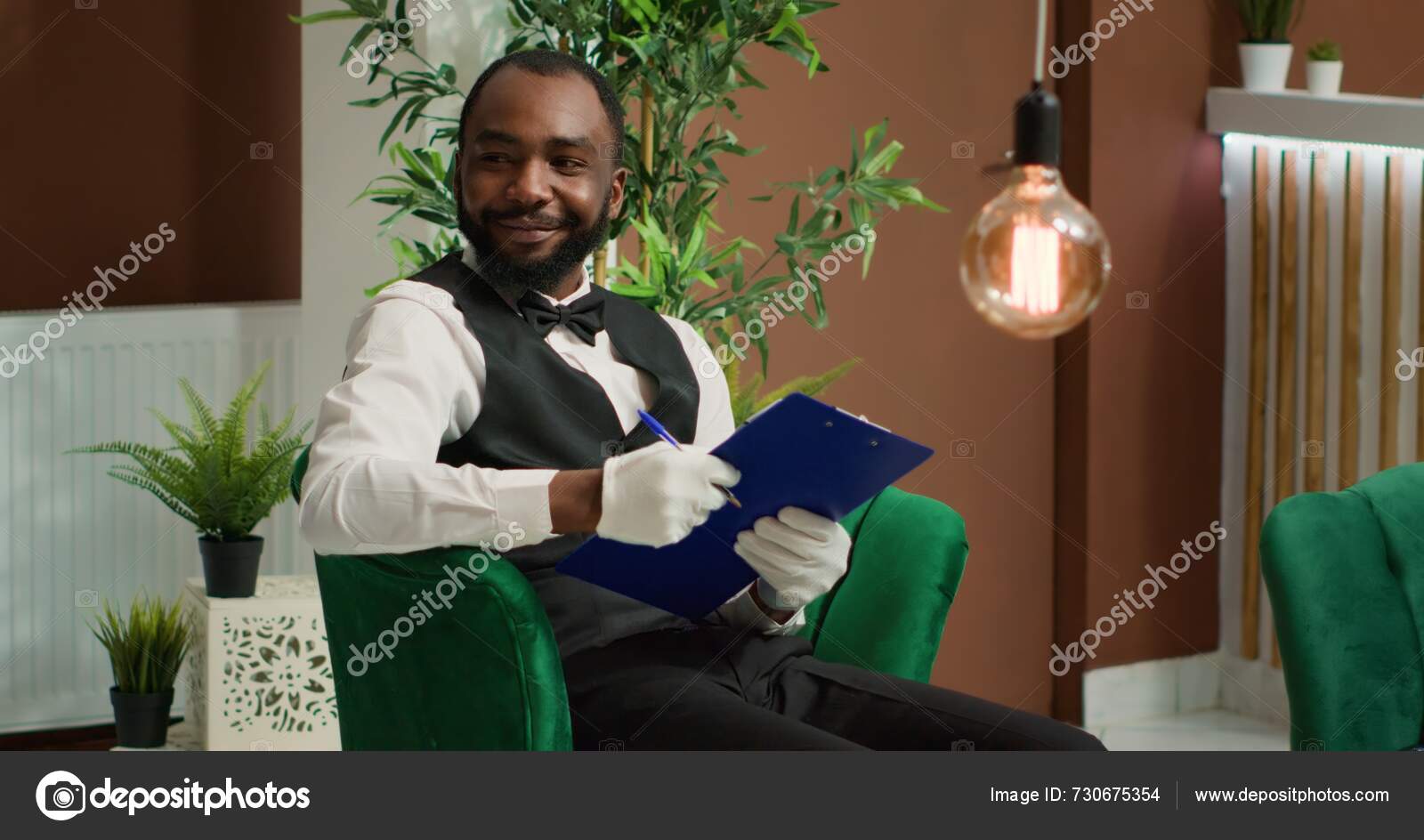 Friendly Hotel Porter Using Clipboard Lounge Area Writing List Guests ...