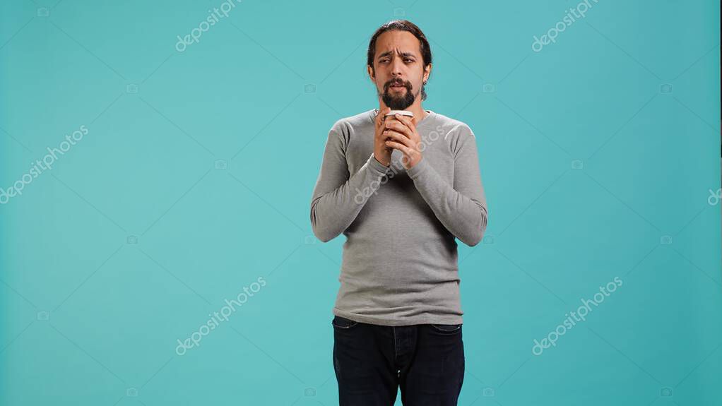 Hombre sintiéndose cansado, bebiendo café para despertar en su camino ...