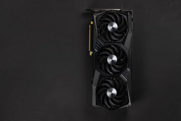 Large and powerful graphics card with three fans on dark background ...