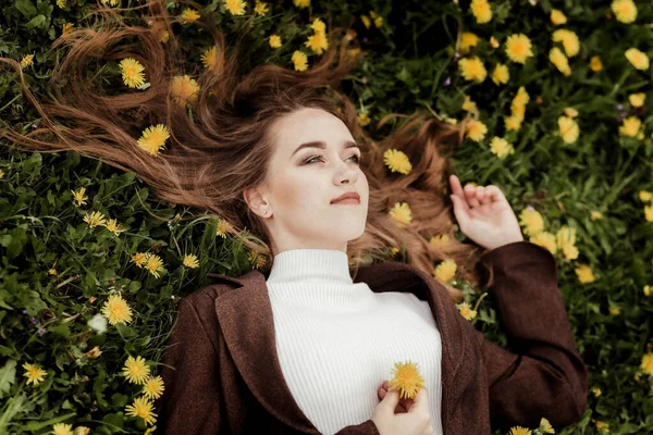 Kinky female brown hair on green grass and yellow colors of a kulbub ...