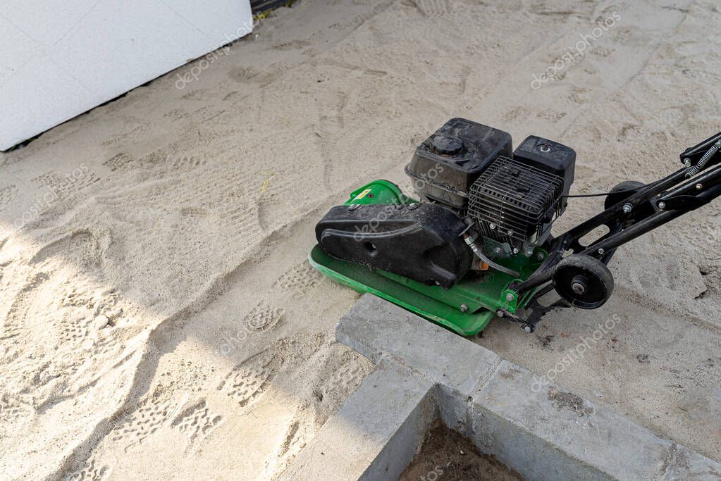Arena compactada en una terraza en construcción, utilizando un ...