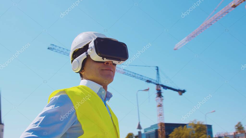 Constructor profesional en casco VR parado frente al sitio de construcci n y utilizando tecnolog ...