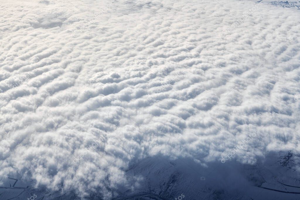 Over clouds top view from aircraft window, thick white blue clouds ...