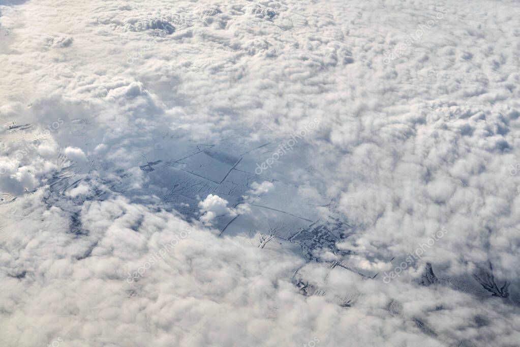 Over clouds top view from aircraft window, thick white blue clouds ...