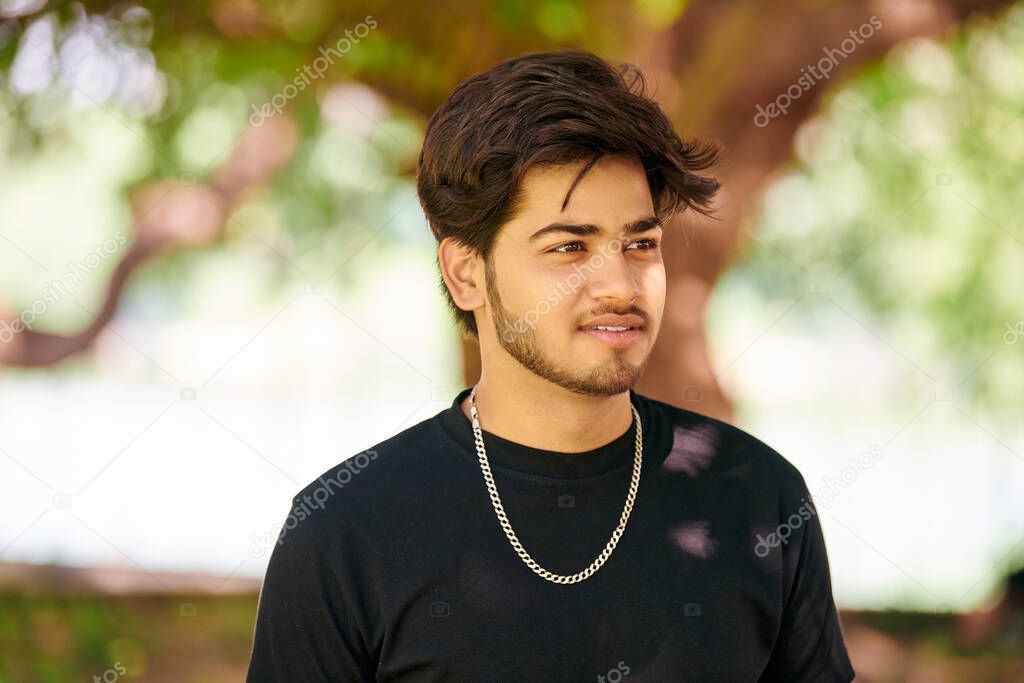 Atractivo retrato de hombre joven indio en camiseta negra y cadena de ...