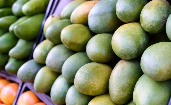Ripe green mangoes at the fruit market. Harvest of exotic sweet mangoes ...