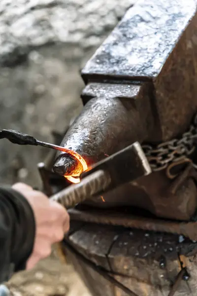 Blacksmith in a forge at work on an anvil. Hot metal forging. High ...