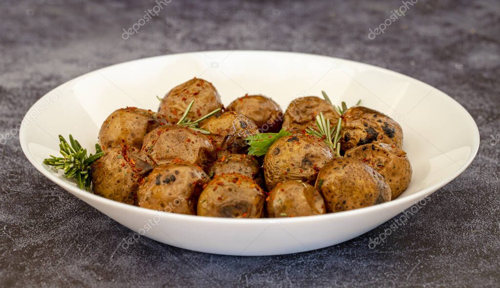 Patatas fritas (horneadas) enteras pequeñas con romero y sal en una ...