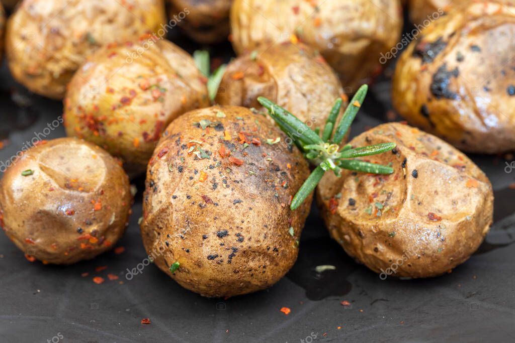 Patatas fritas (horneadas) enteras pequeñas con romero y sal en una ...