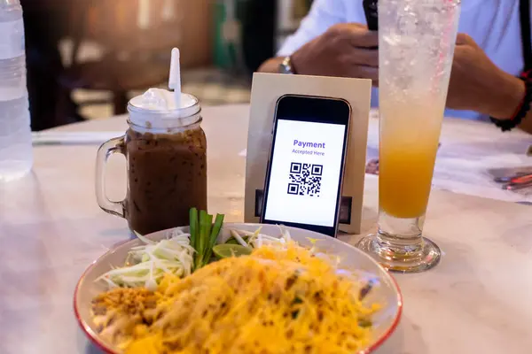 Qr Code tag on smartphone with blurry Thai food in cafe or restaurant ...