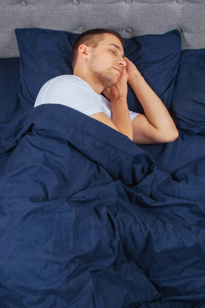 Top view of a handsome young man sleeping comfortably on the bed at ...