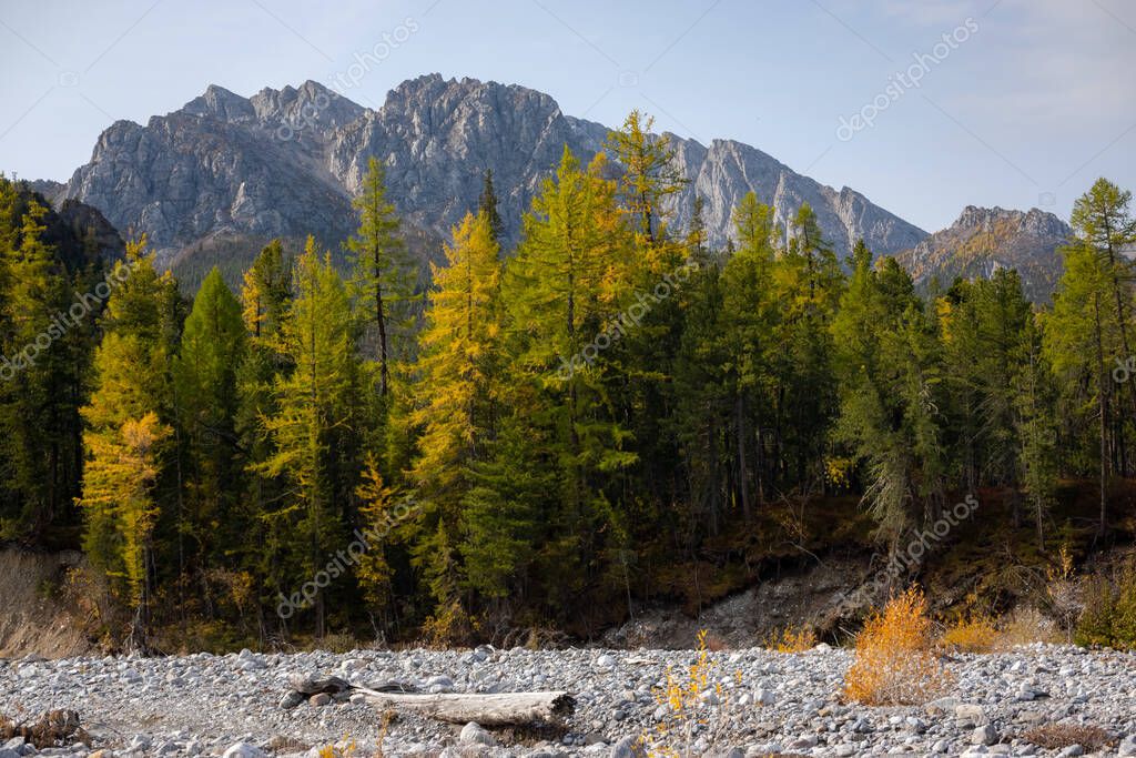Lecho de río seco en un campo rural con las montañas nevadas en el ...